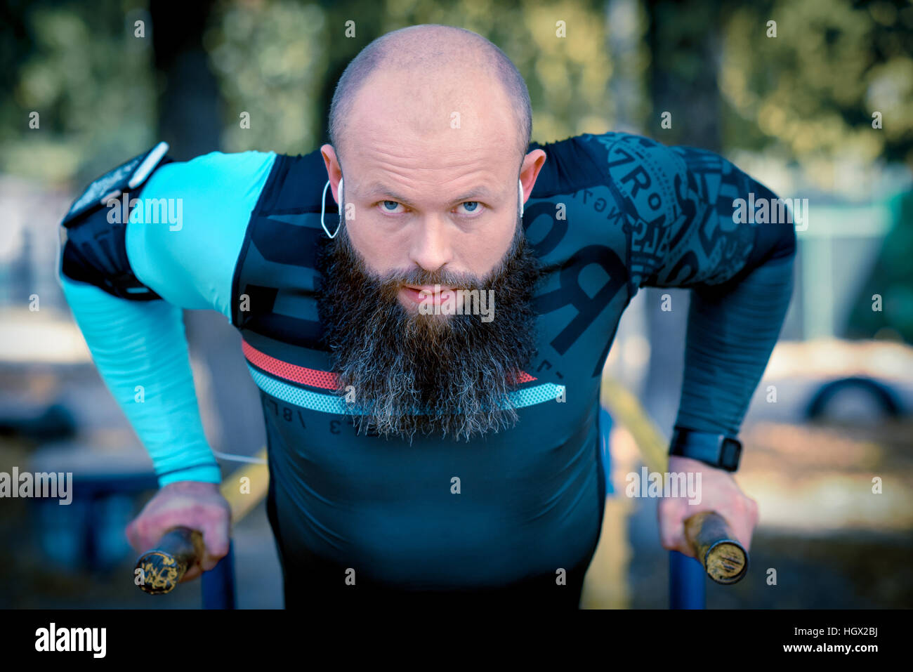 Man doing push ups on parallel bars in a park Stock Photo - Alamy