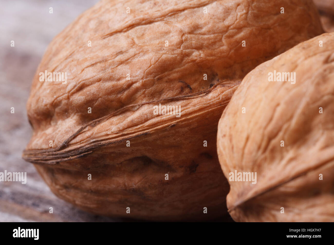 two walnuts in the shell macro on an old wooden table Stock Photo - Alamy