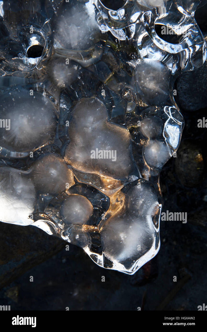 Dimpled patterns in sea ice on an Alaskan beach at sunset close up ...