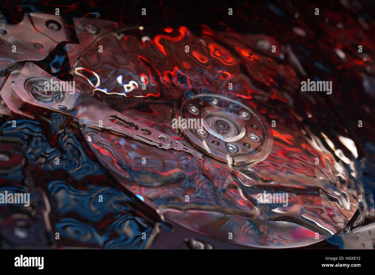 Opened Computer hard disk drive in studio with dark red and blue ...