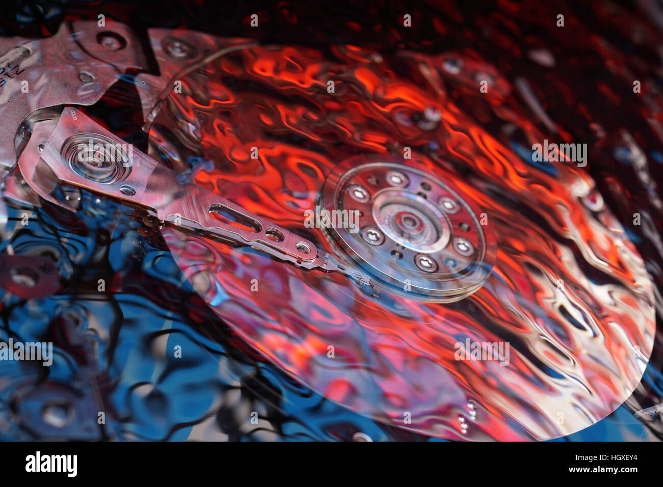 Opened Computer hard disk drive in studio with dark red and blue ...