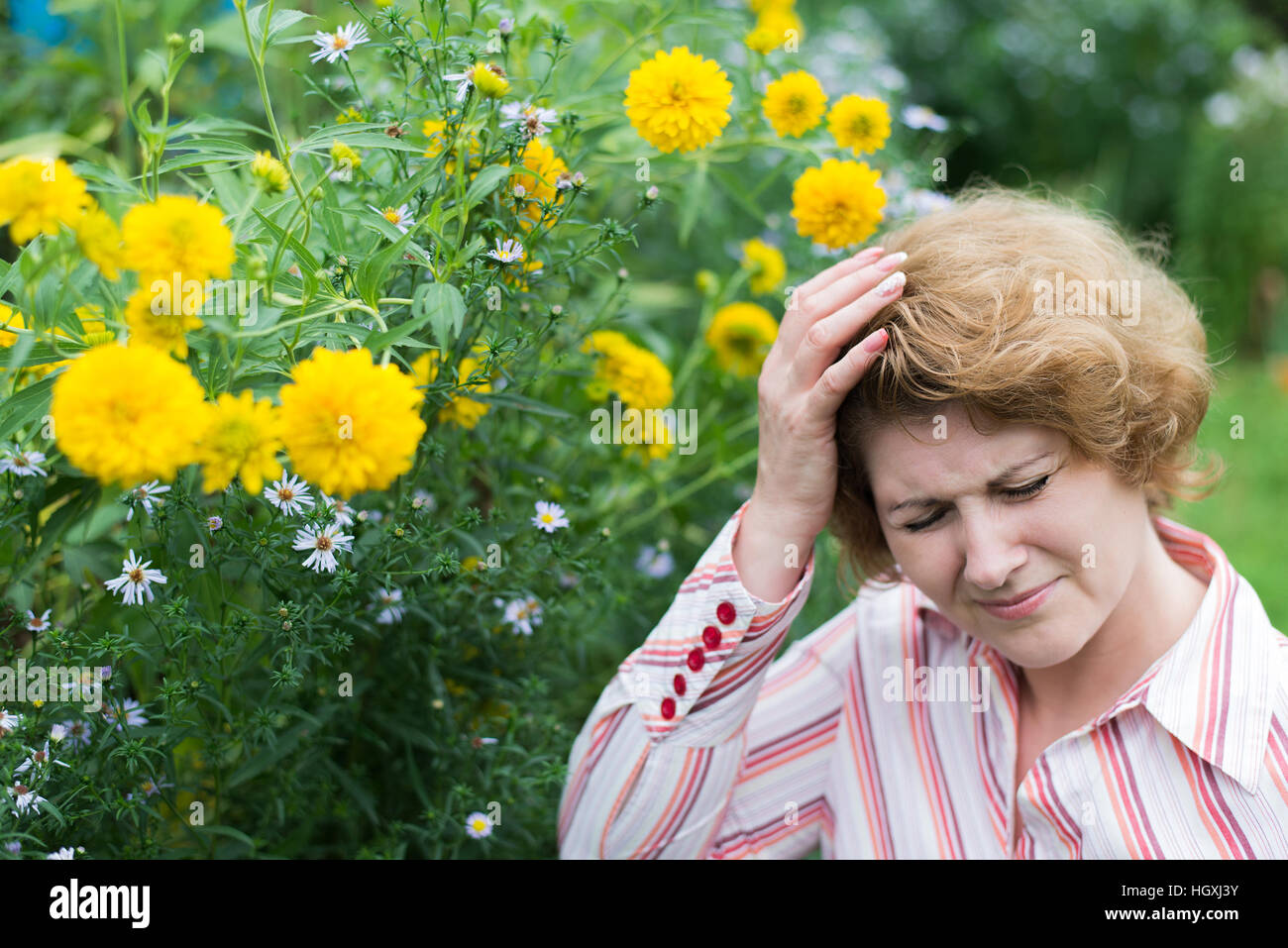 Woman suffering from headache allergic to flowers Stock Photo - Alamy