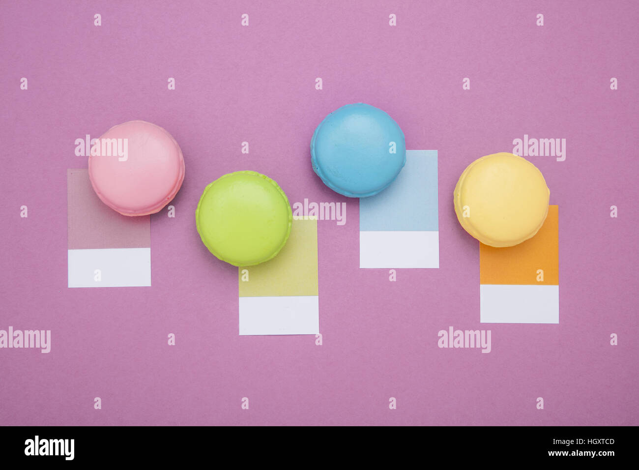 Four macaroons pink, green, blue and yellow against purple Stock Photo ...