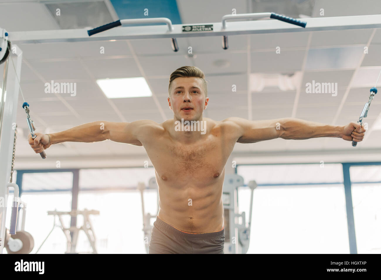 close up photo of attractive man training on Fitness-station. Guy with ...
