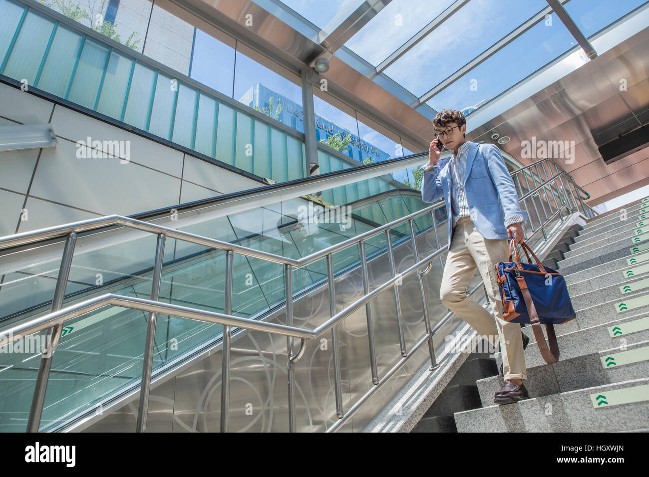 Businessman going downstairs talking on cellphone Stock Photo - Alamy