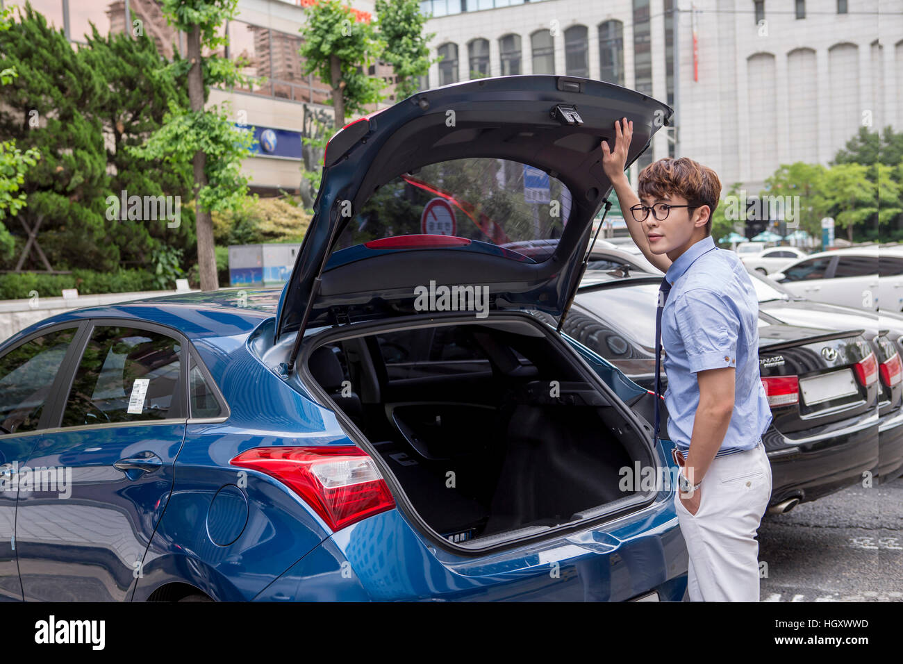 Businessman opening trunk in his car Stock Photo - Alamy