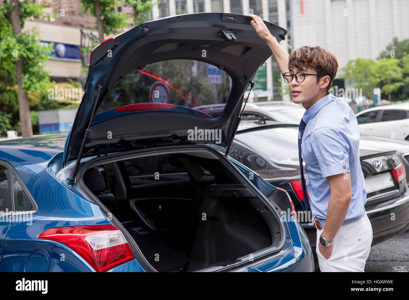 Businessman opening trunk in his car Stock Photo - Alamy