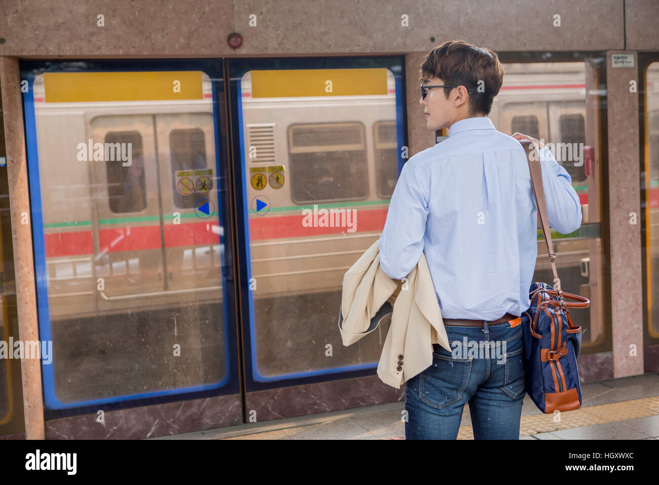 Back of businessman waiting for train Stock Photo - Alamy