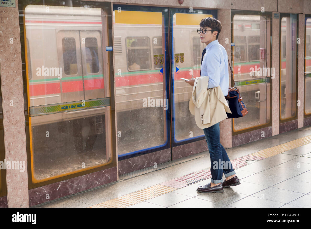 Businessman waiting for train Stock Photo - Alamy