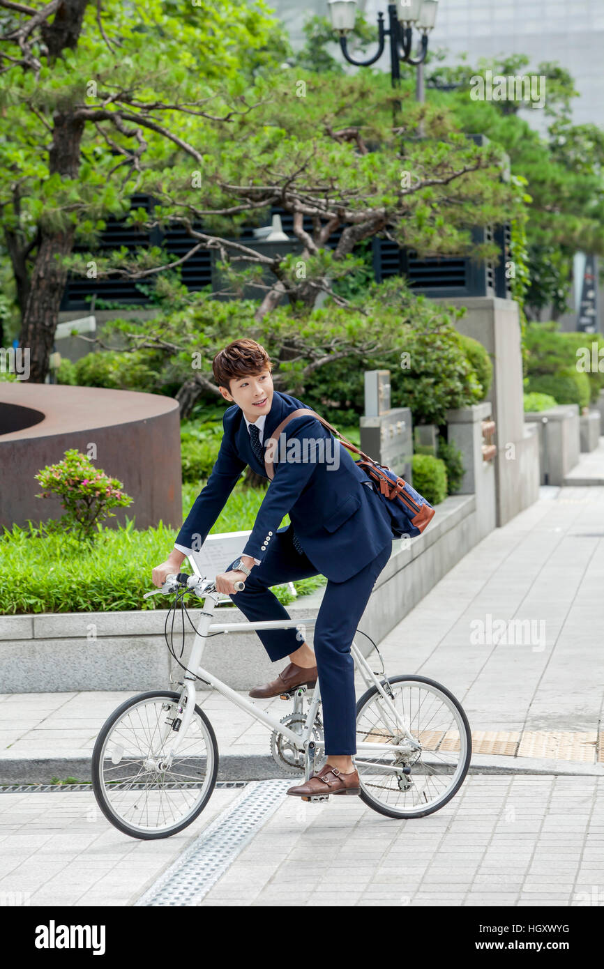 Smiling businessman riding bicycle Stock Photo - Alamy
