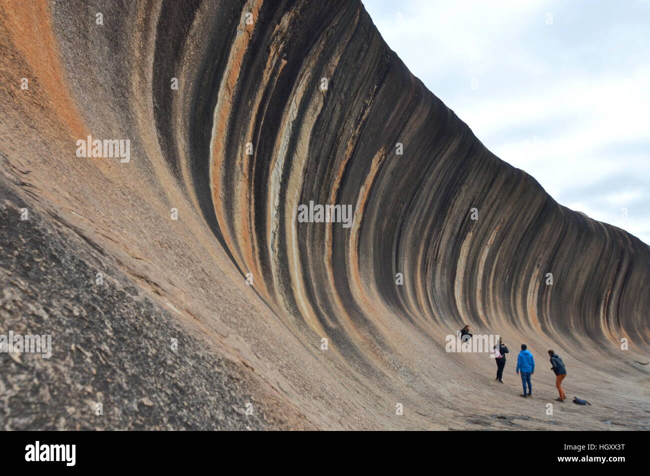 Concave striped slope of Wave Rock with some tourists in the distance ...