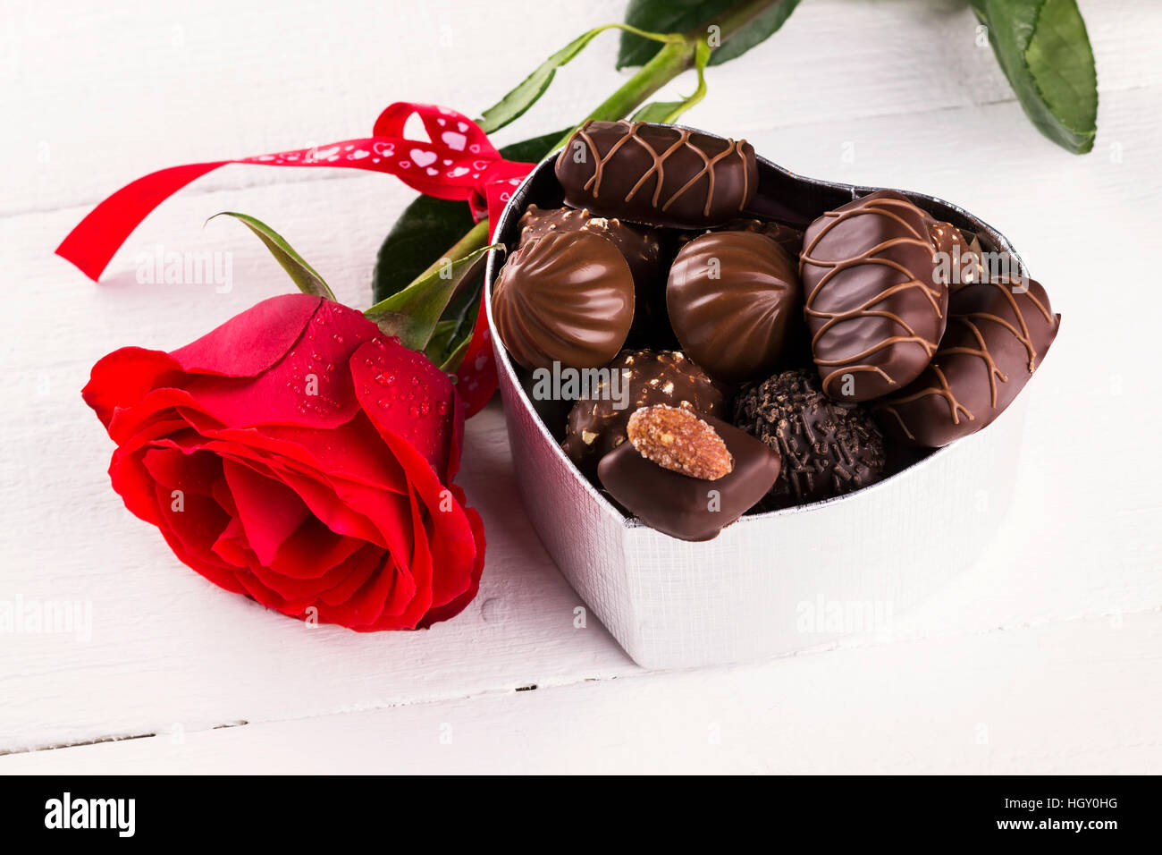 Red rose, box of chocolates on a white wooden background Stock Photo ...