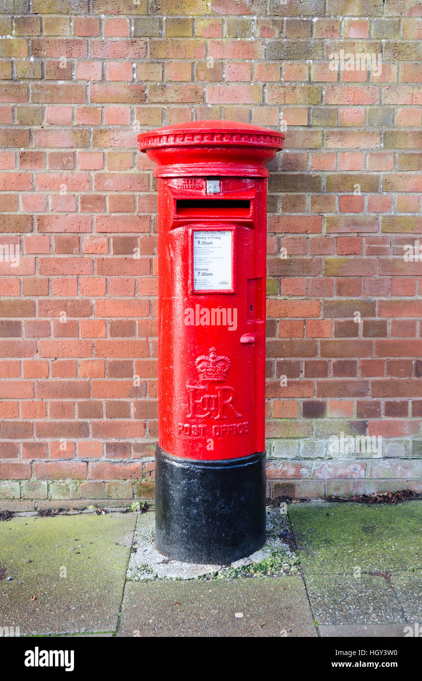 Red post box in front of a brick wall Stock Photo - Alamy