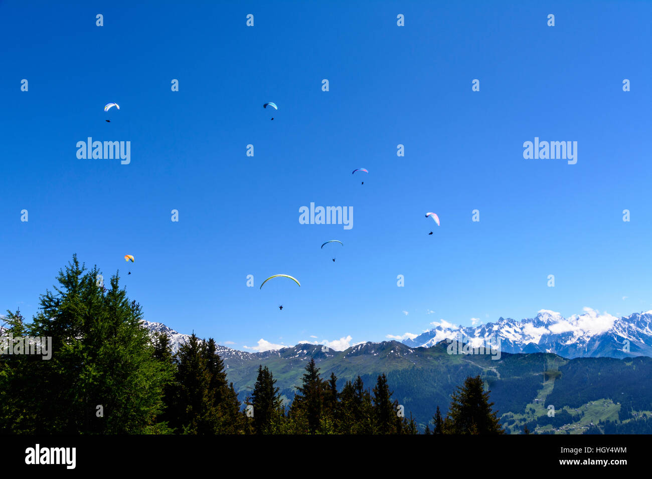Paragliders soaring high over the alps in Verbier, Switzerland in the ...