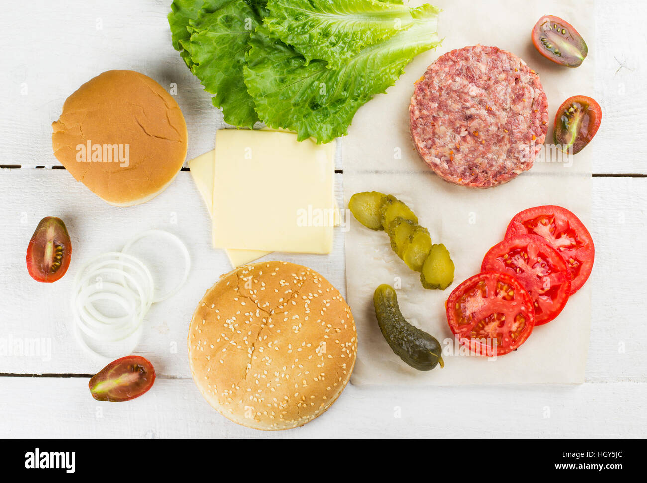 Ingredients for burger: meat, roll with sesame, cheese, lettuce, onions ...