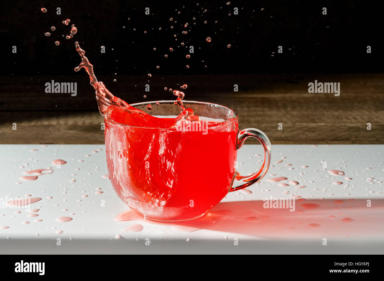 Juice in a Cup and splash with spray on dark background Stock Photo - Alamy