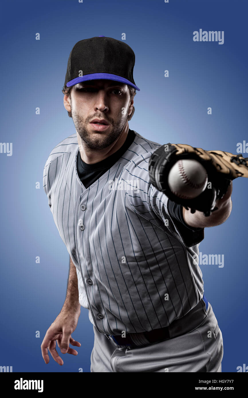 Baseball Player on a Blue Uniform on blue background Stock Photo - Alamy