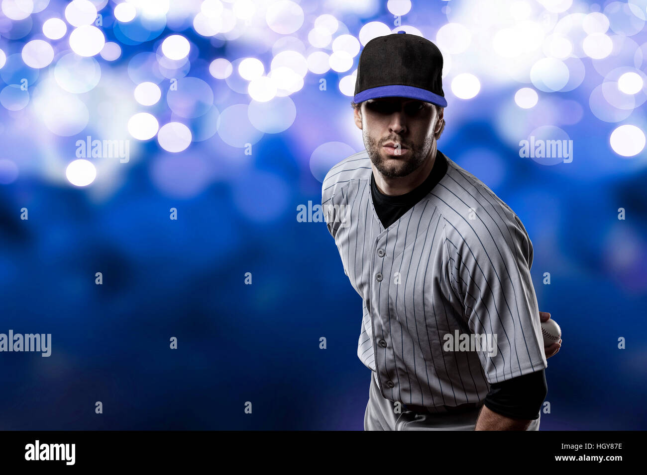 Baseball Player on a Blue Uniform on blue lights background Stock Photo ...