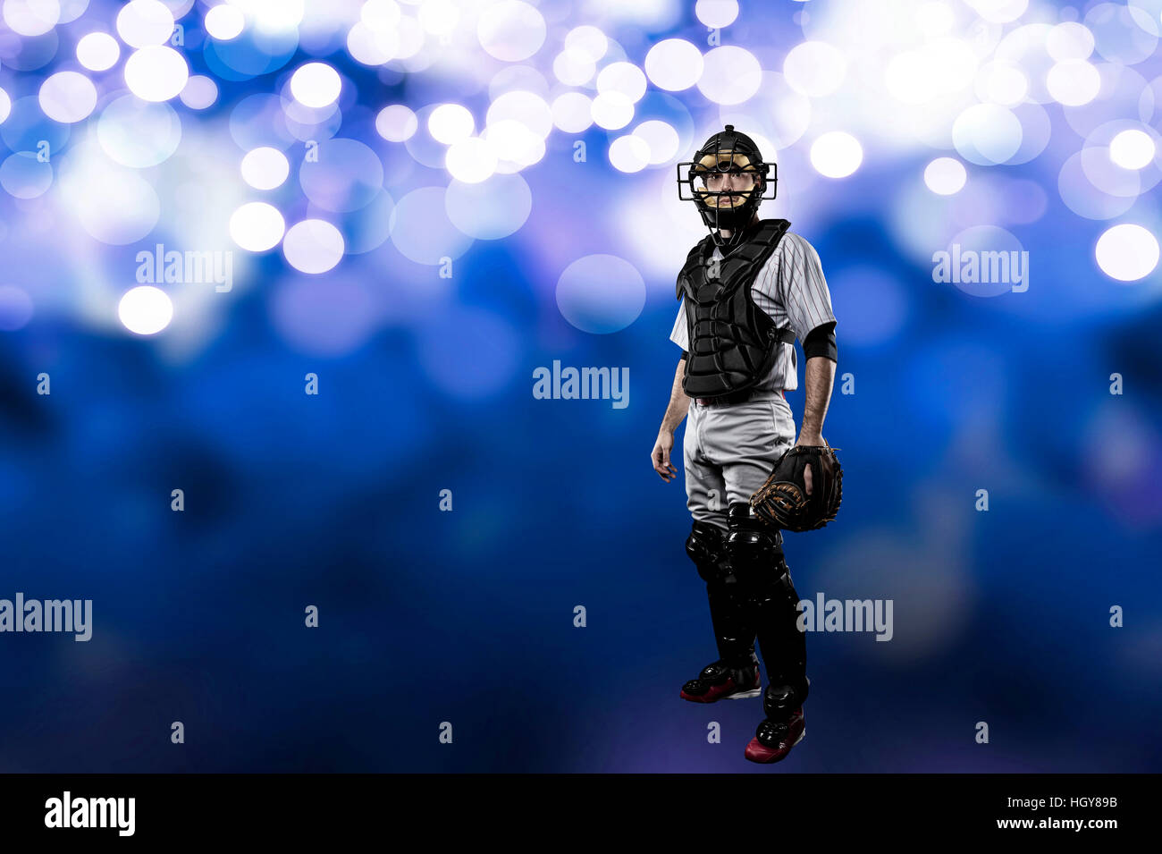 Catcher Baseball Player on a blue lights background Stock Photo - Alamy