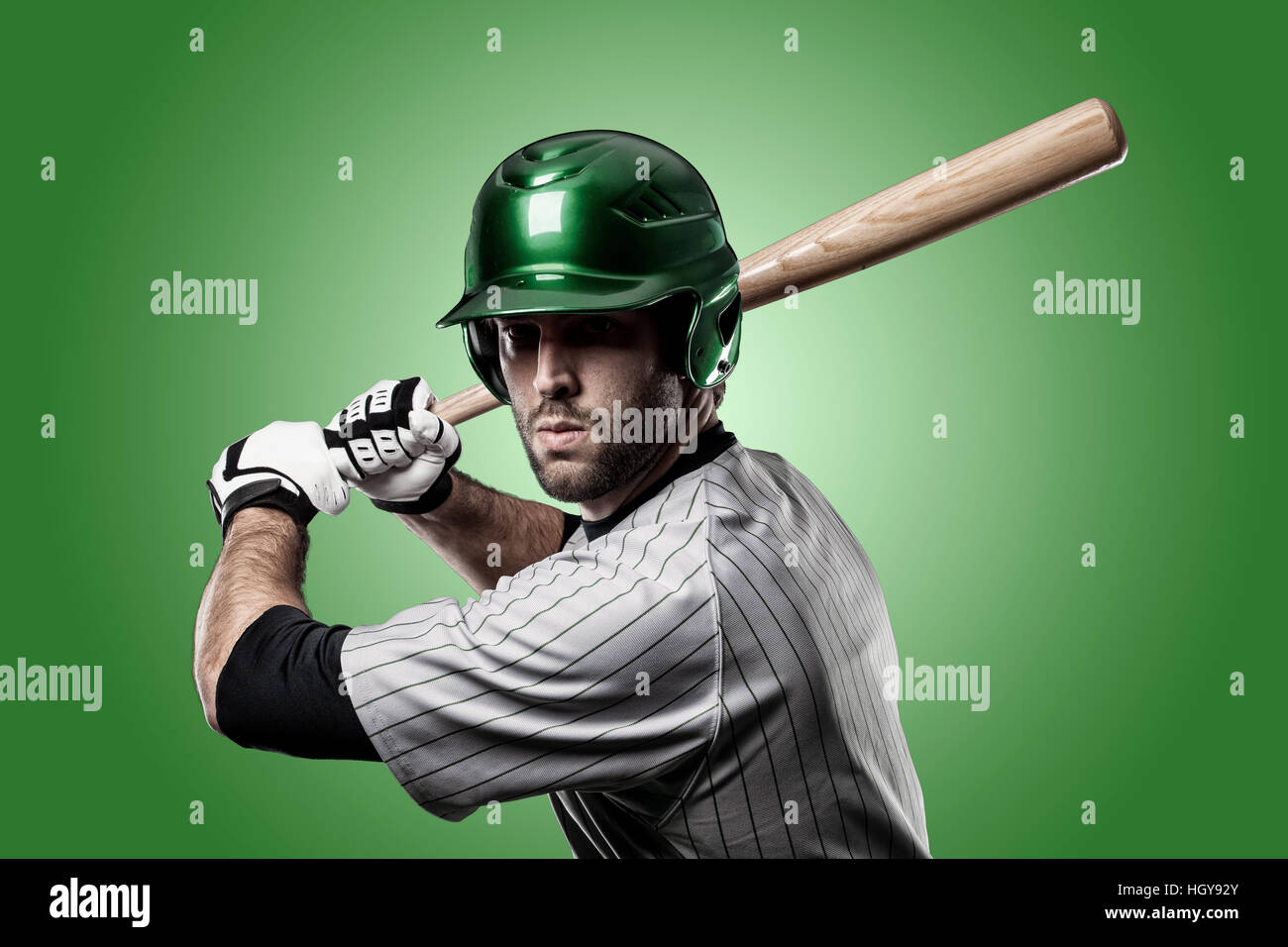 Baseball Player on a Green Uniform on Green background Stock Photo - Alamy