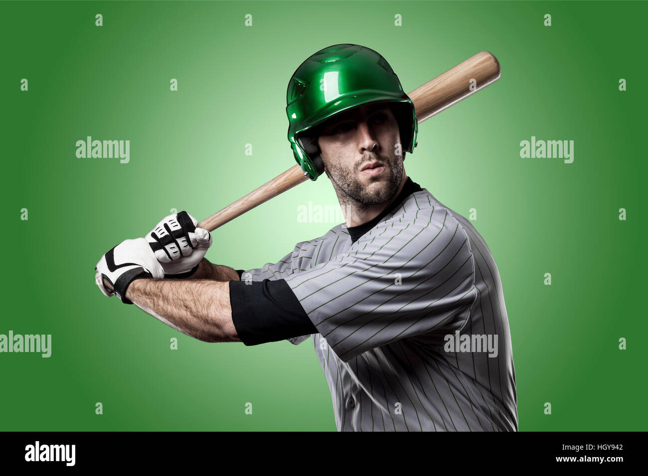 Baseball Player on a Green Uniform on Green background Stock Photo - Alamy