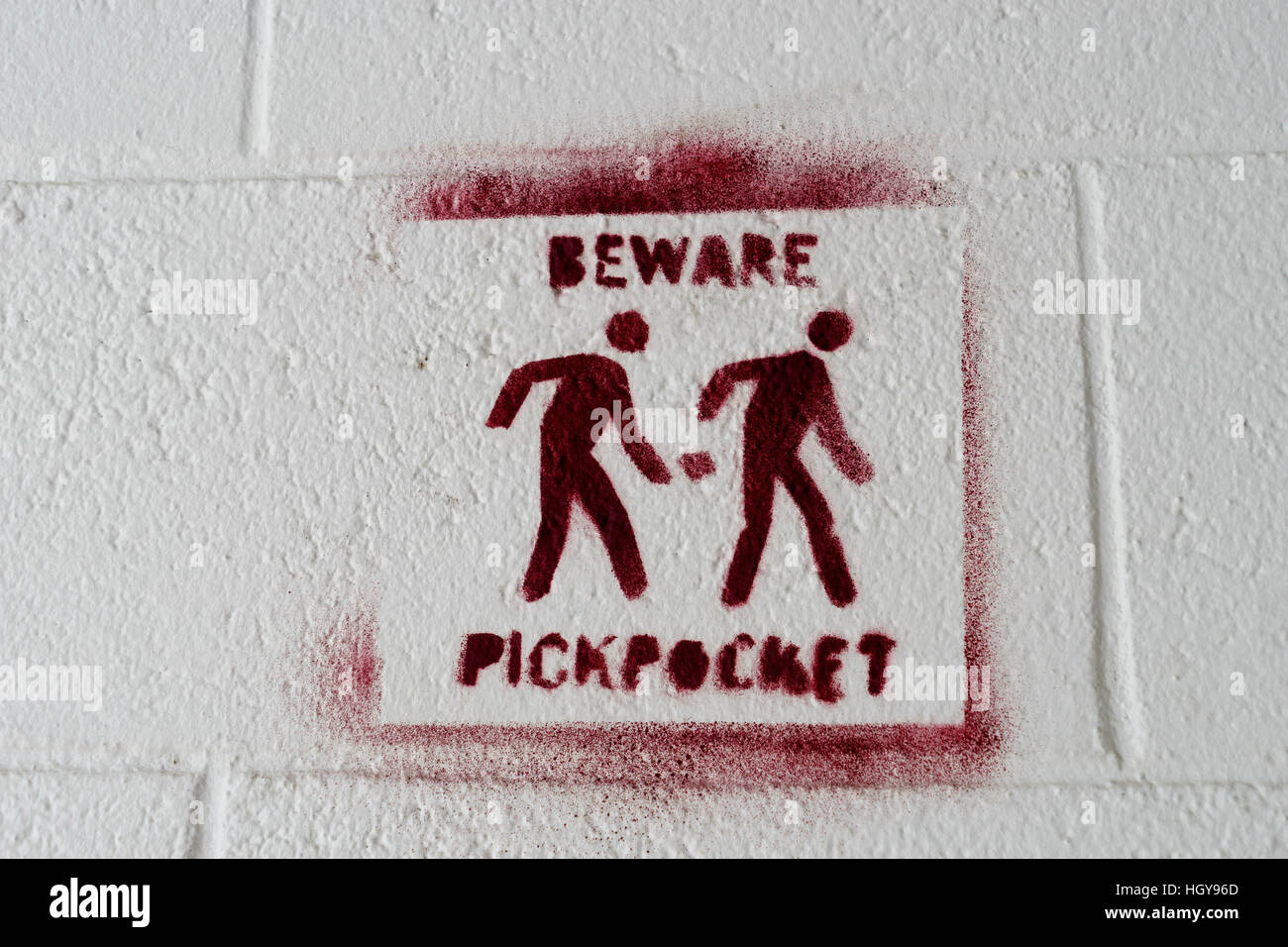 Pickpocket warning sign stencilled on to a white wall Stock Photo - Alamy