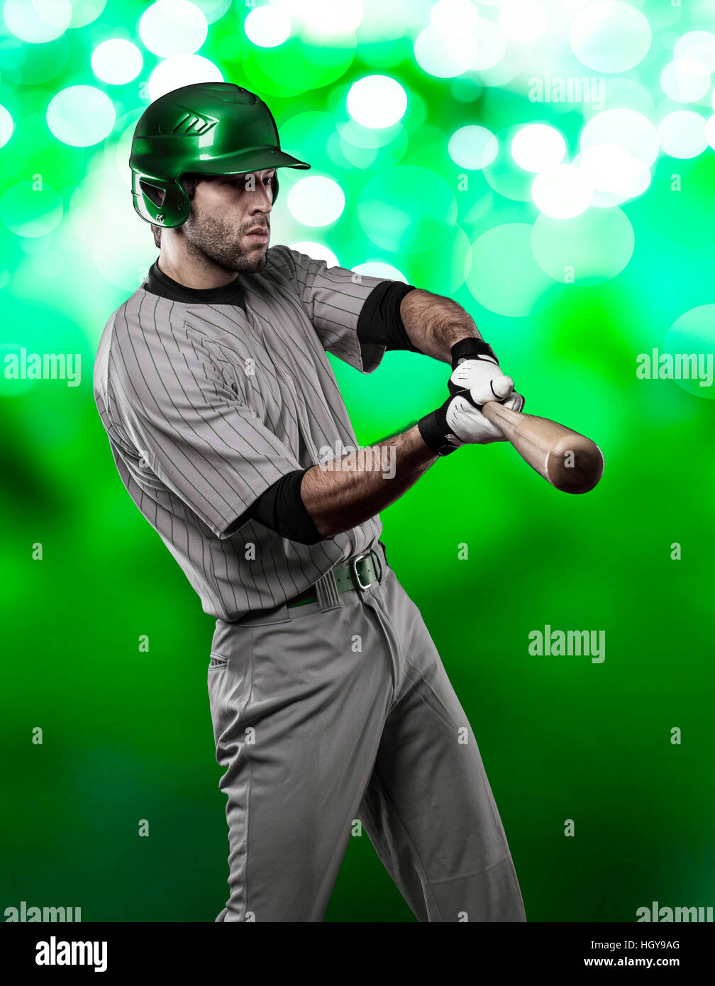 Baseball Player on a Green Uniform on Green lights background Stock ...