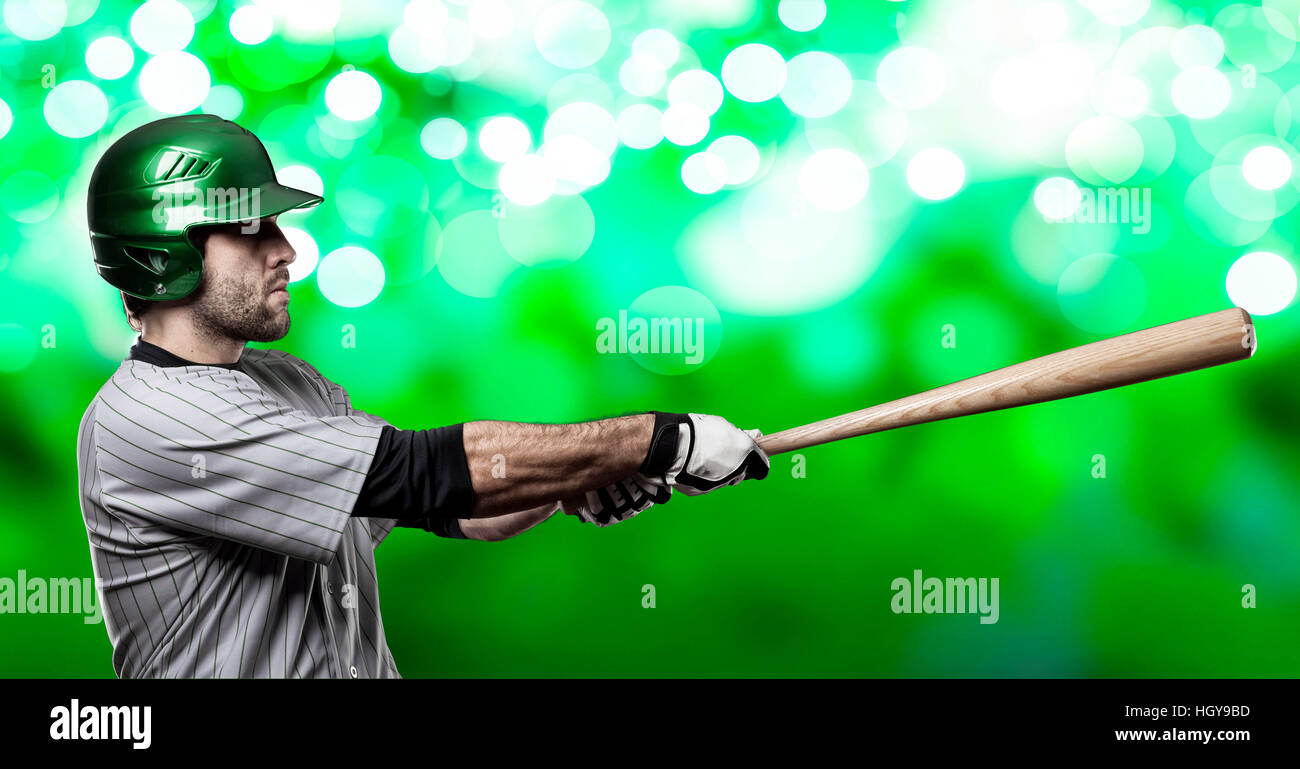 Baseball Player on a Green Uniform on Green lights background Stock ...