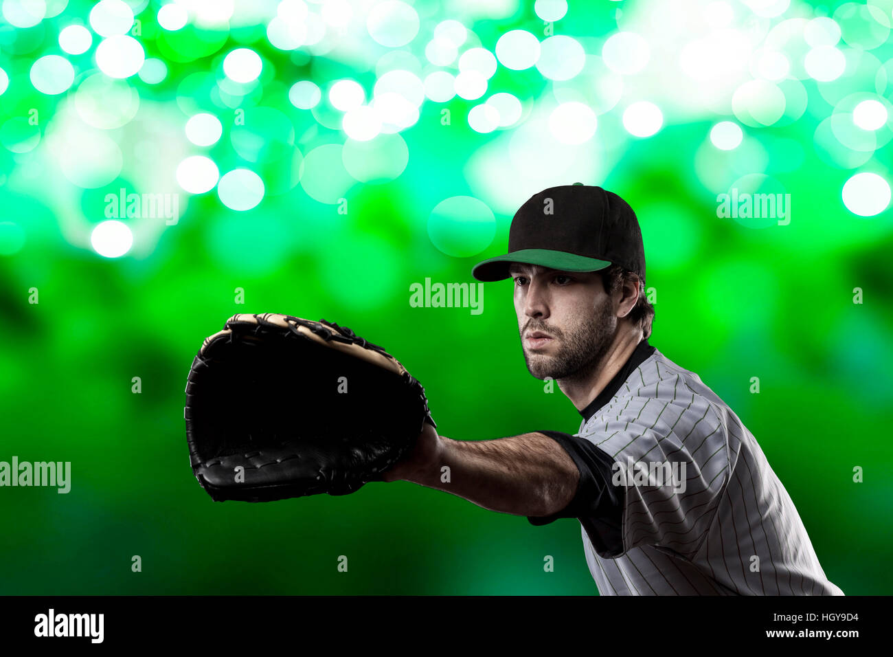 Baseball Player on a Green Uniform on Green lights background Stock ...