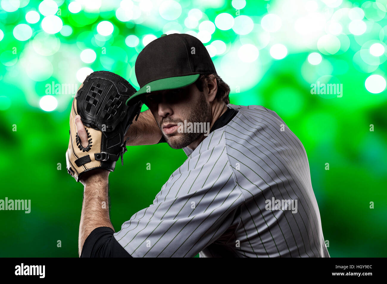 Baseball Player on a Green Uniform on Green lights background Stock ...