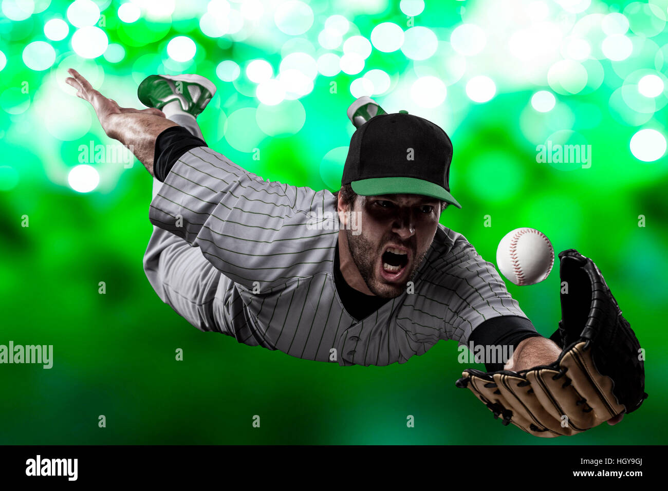Baseball Player on a Green Uniform on Green lights background Stock ...
