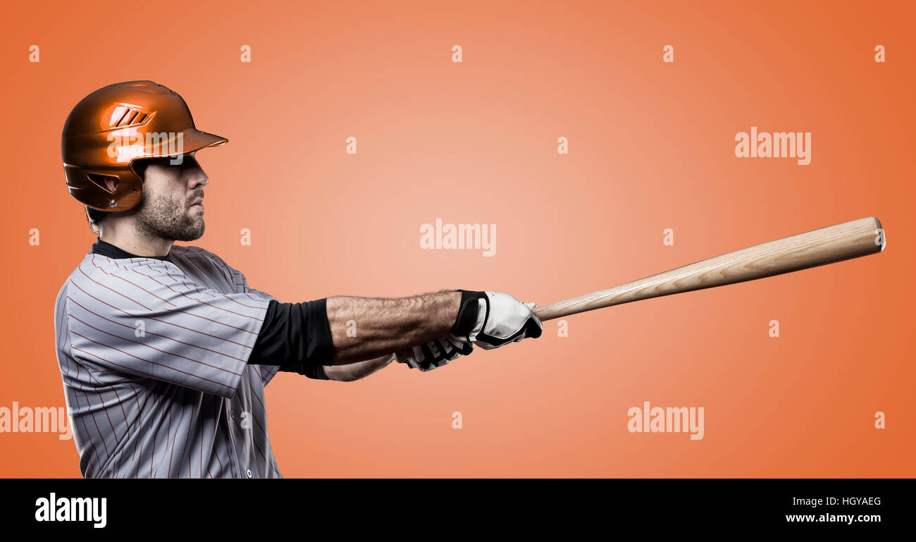 Baseball Player on a orange Uniform on orange background Stock Photo ...