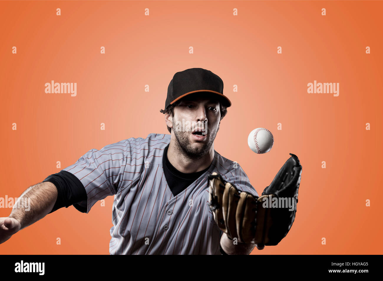 Baseball Player on a orange Uniform on orange background Stock Photo ...