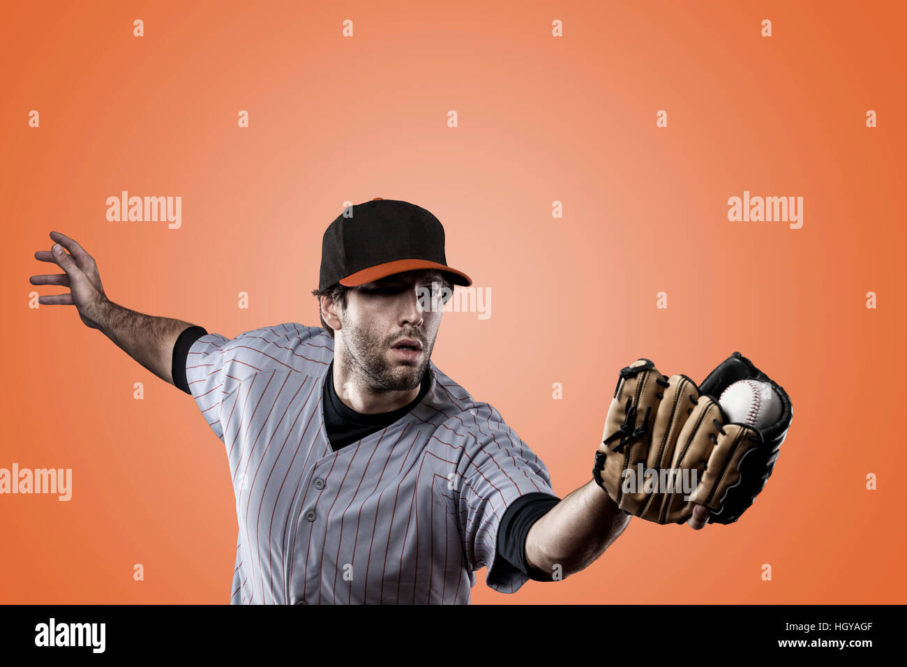 Baseball Player on a orange Uniform on orange background Stock Photo ...