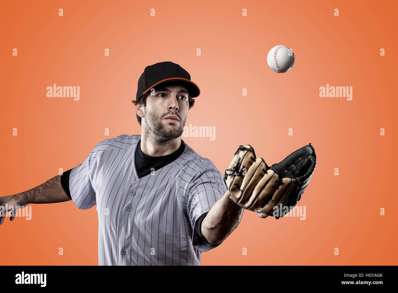 Baseball Player on a orange Uniform on orange background Stock Photo ...