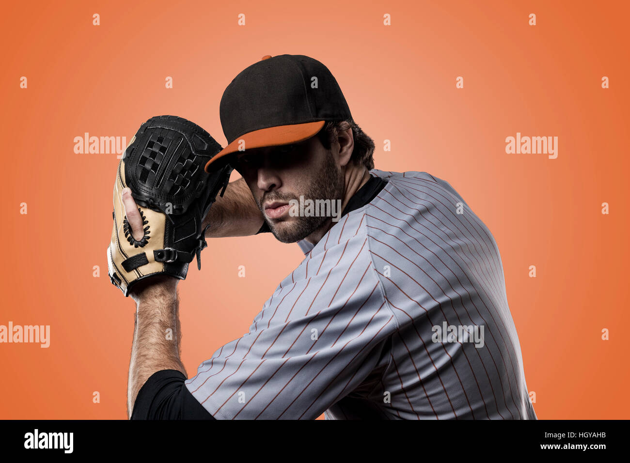 Baseball Player on a orange Uniform on orange background Stock Photo ...