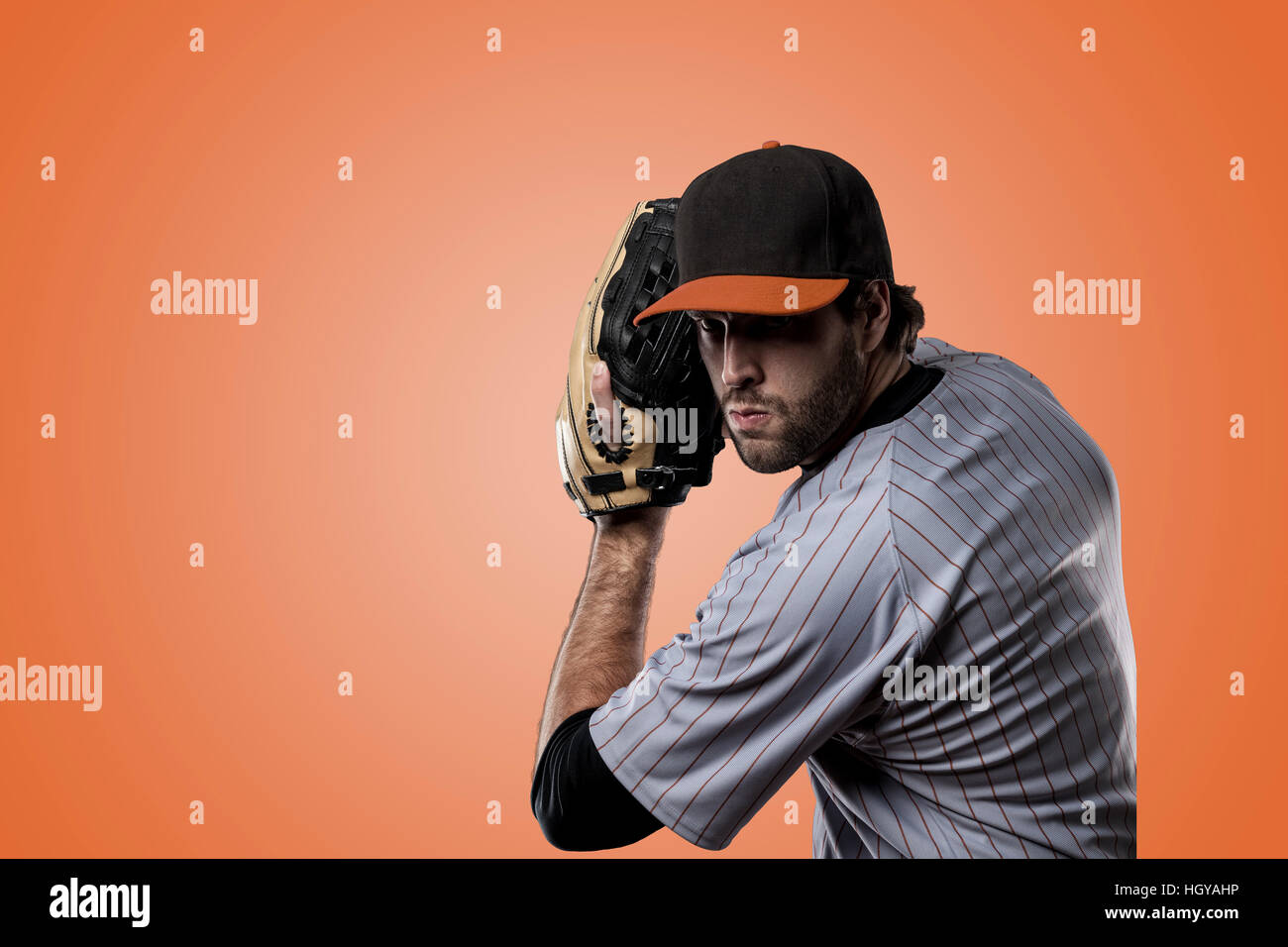 Baseball Player on a orange Uniform on orange background Stock Photo ...