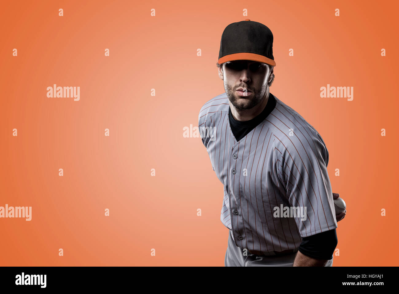Baseball Player on a orange Uniform on orange background Stock Photo ...