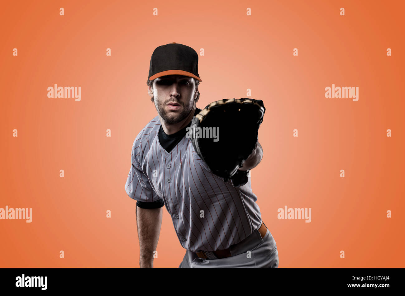 Baseball Player on a orange Uniform on orange background Stock Photo ...