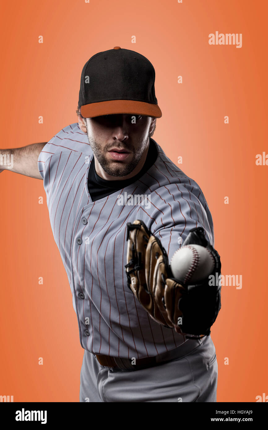 Baseball Player on a orange Uniform on orange background Stock Photo ...