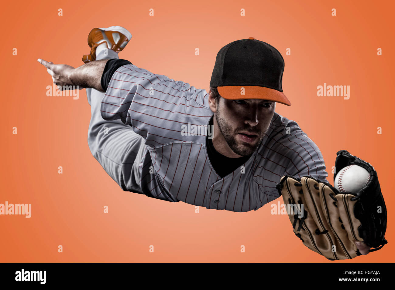 Baseball Player on a orange Uniform on orange background Stock Photo ...