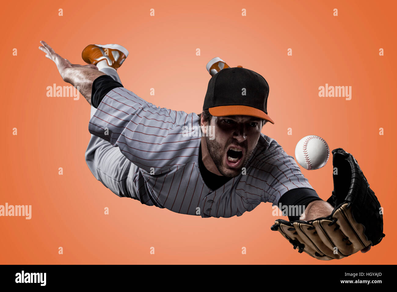 Baseball Player on a orange Uniform on orange background Stock Photo ...