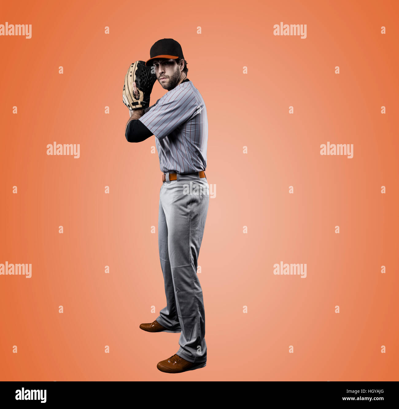 Pitcher Baseball Player on a orange Uniform on orange background Stock ...