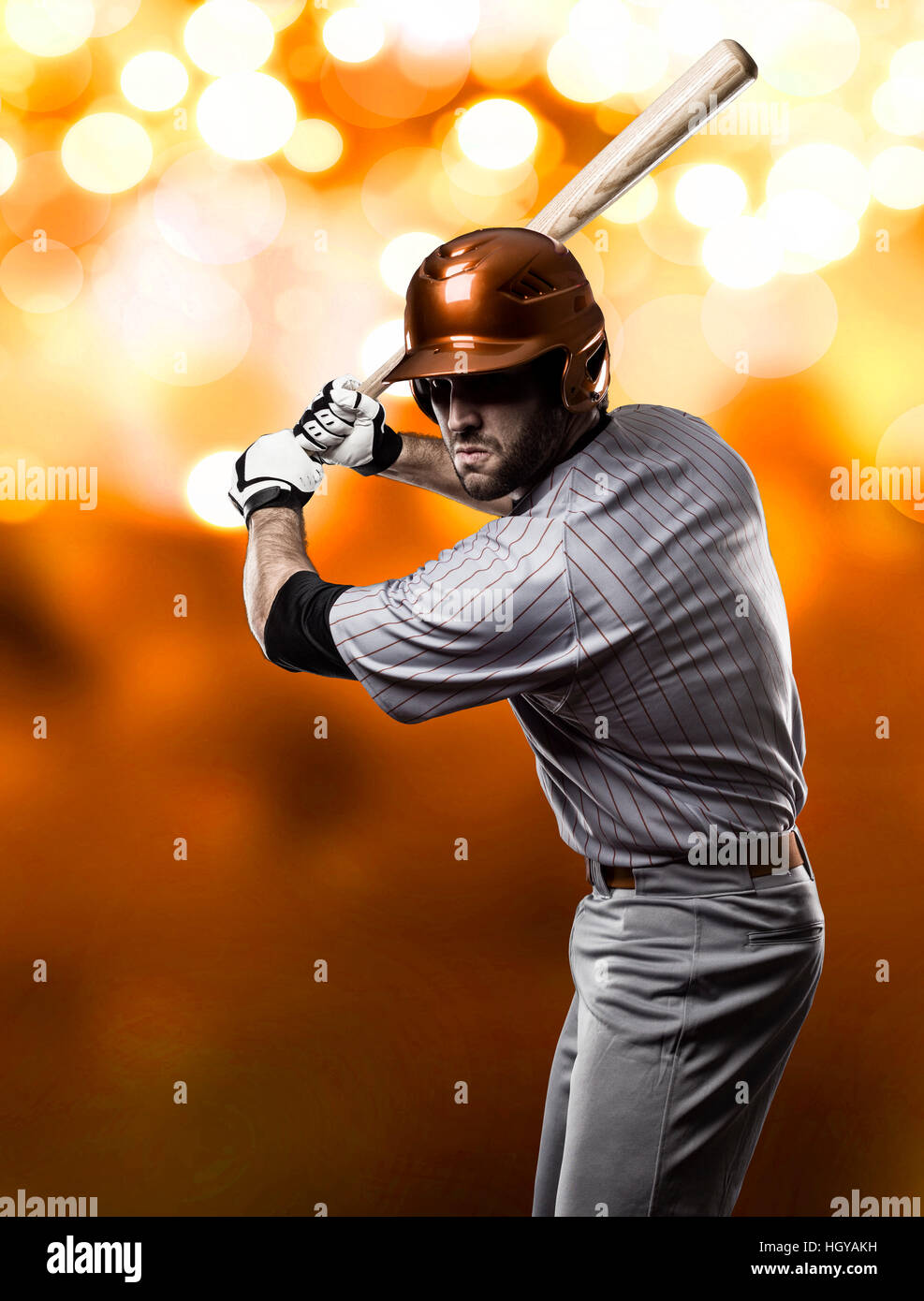 Baseball Player on a orange Uniform on orange lights background Stock ...