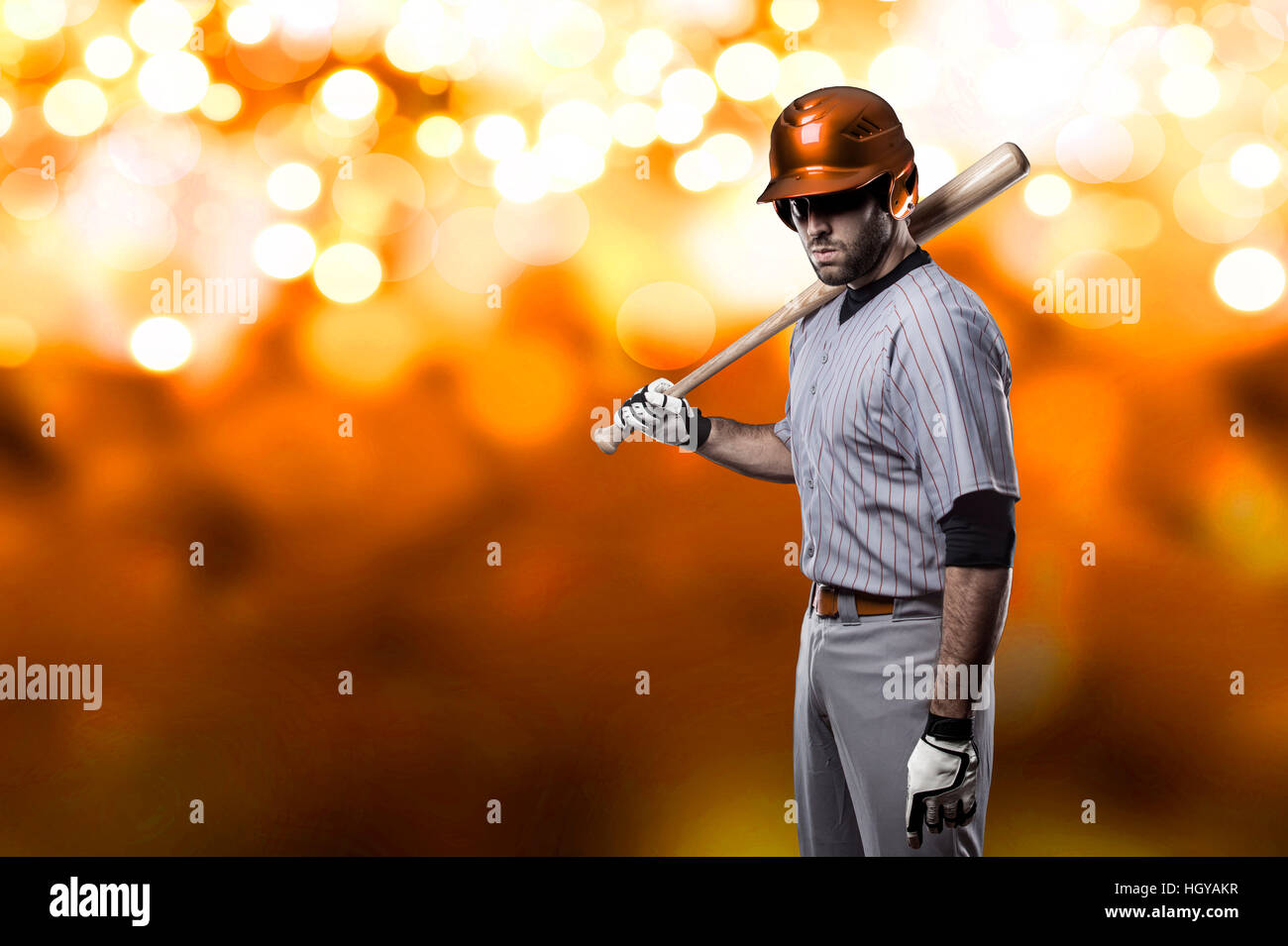 Baseball Player on a orange Uniform on orange lights background Stock ...
