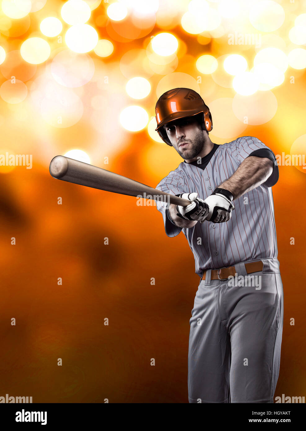 Baseball Player on a orange Uniform on orange lights background Stock ...