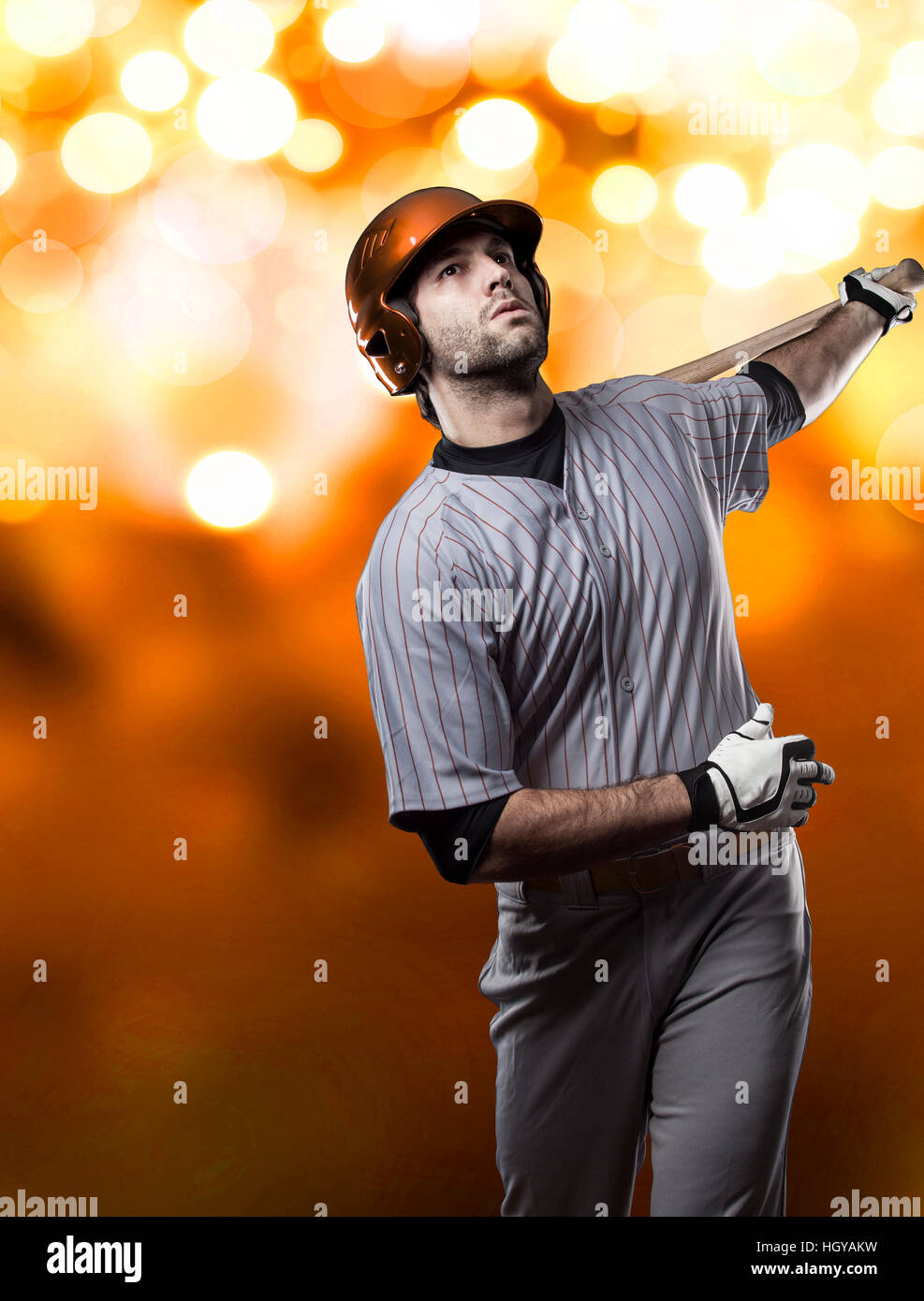 Baseball Player on a orange Uniform on orange lights background Stock ...
