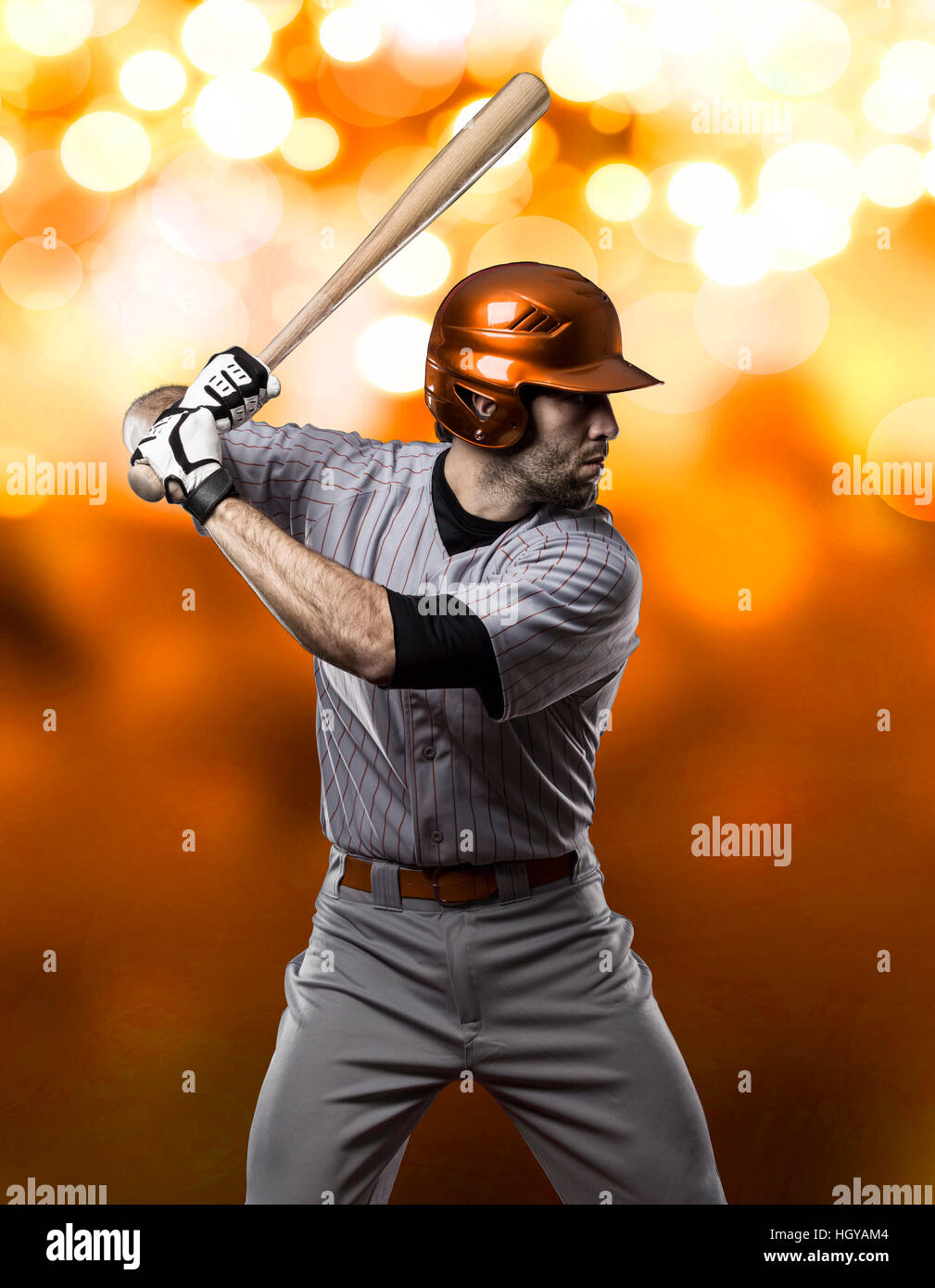 Baseball Player on a orange Uniform on orange lights background Stock ...