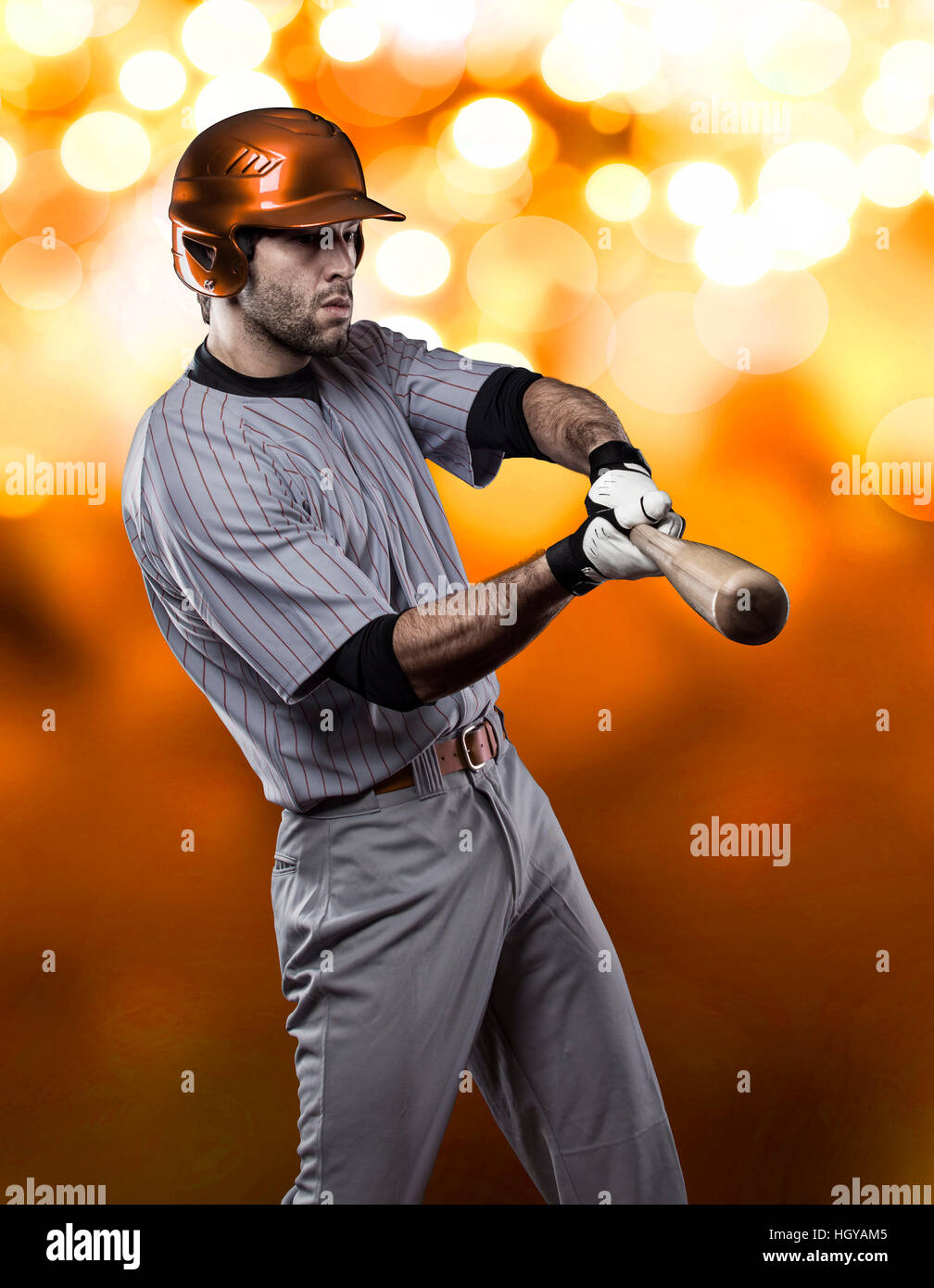 Baseball Player on a orange Uniform on orange lights background Stock ...