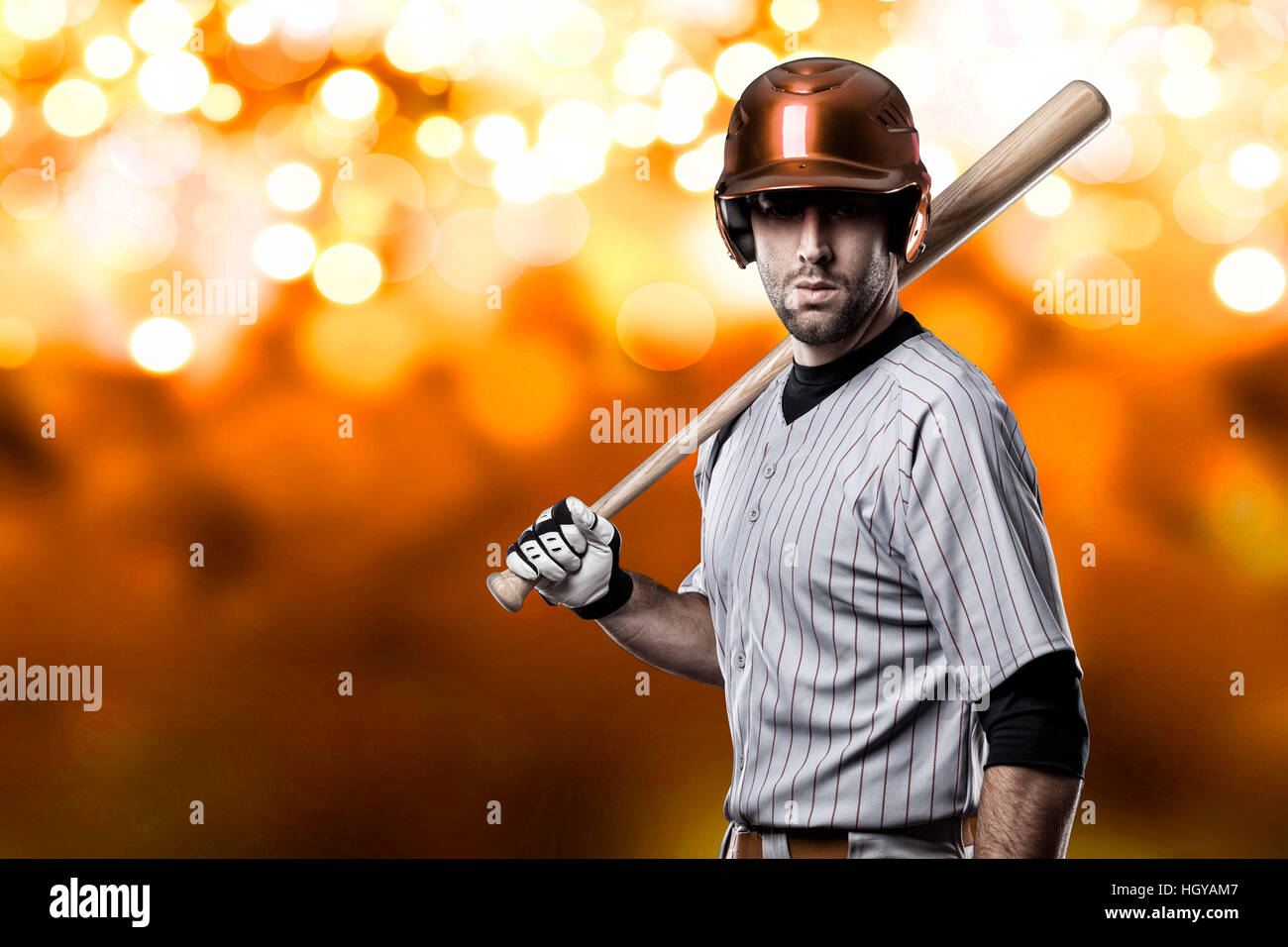 Baseball Player on a orange Uniform on orange lights background Stock ...